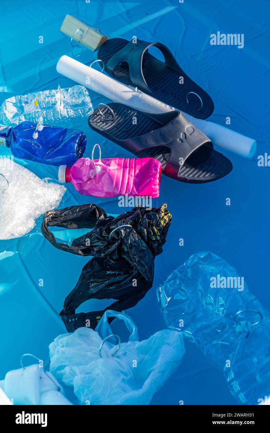 An assortment of Plastic garbage floating in a pool to raise awareness ...