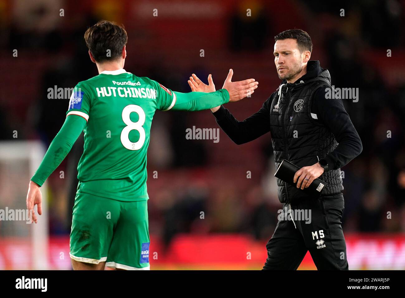 Walsall manager Matthew Sadler (right) shakes hands with player Isaac ...