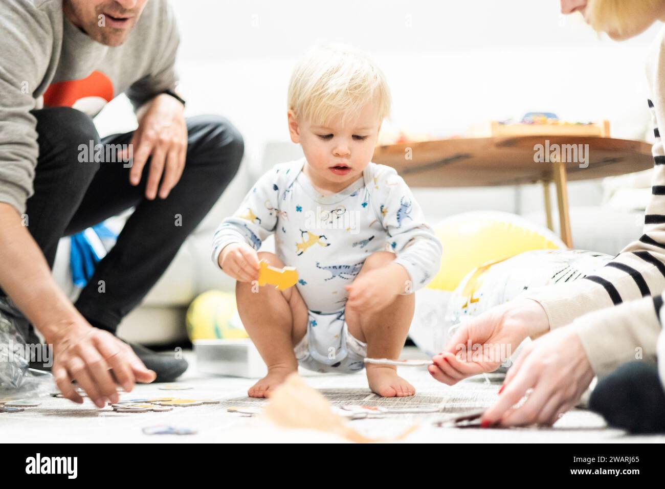 Parents playing games with child. Little toddler doing puzzle. Infant ...