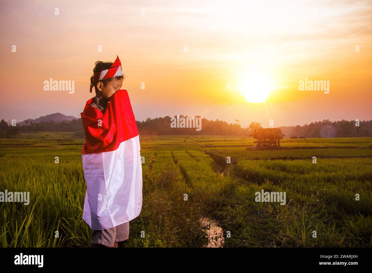 Asian teenager in traditional Javanese clothes standing holding ...