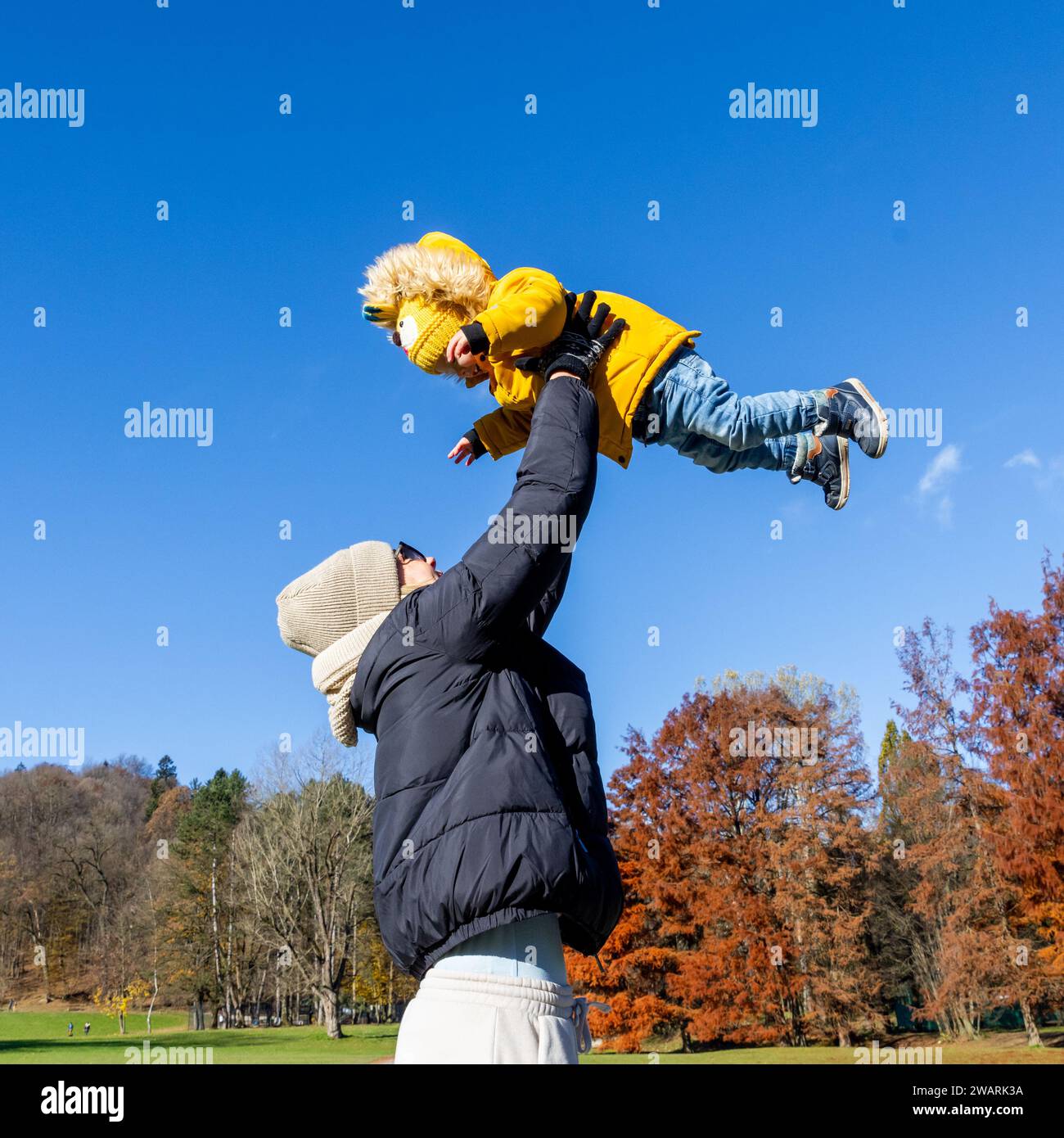 More, more,...mum, that's fun. Happy young mother throws her cute ...