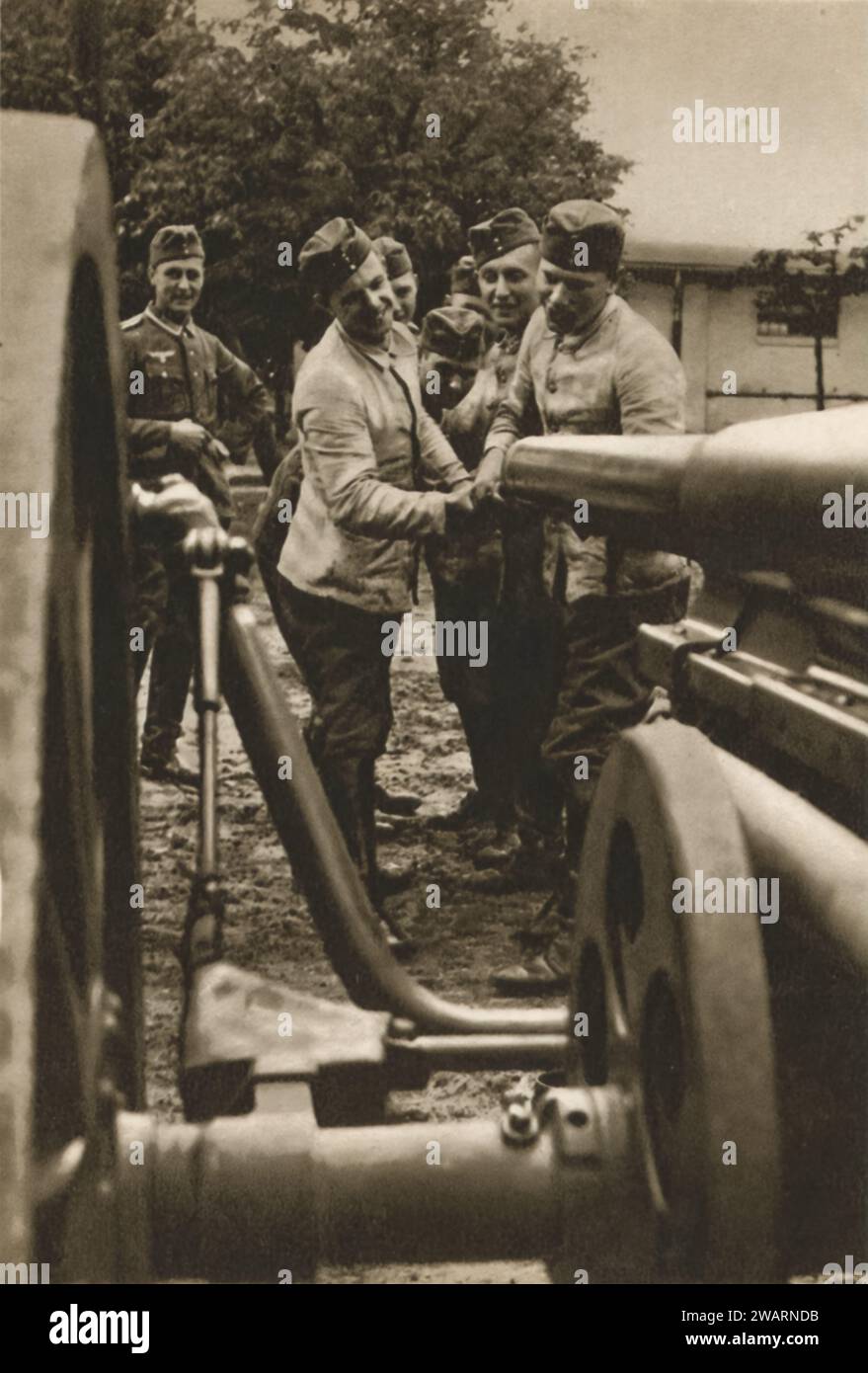 A group of German recruits is shown pulling a heavy artillery cannon ...