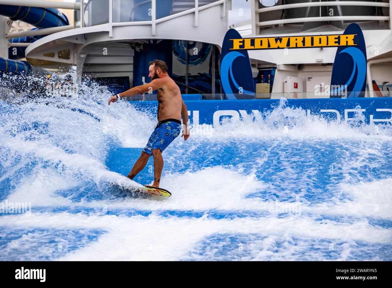 A man standing on a surfboard in the middle of a body of water on a ...
