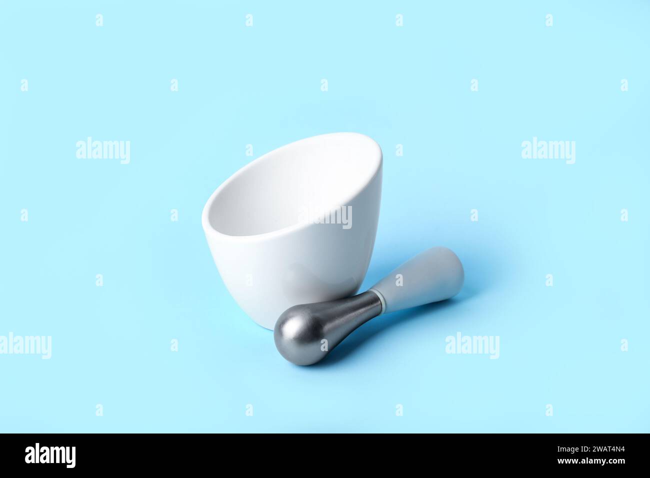 Mortar and pestle on blue background Stock Photo - Alamy