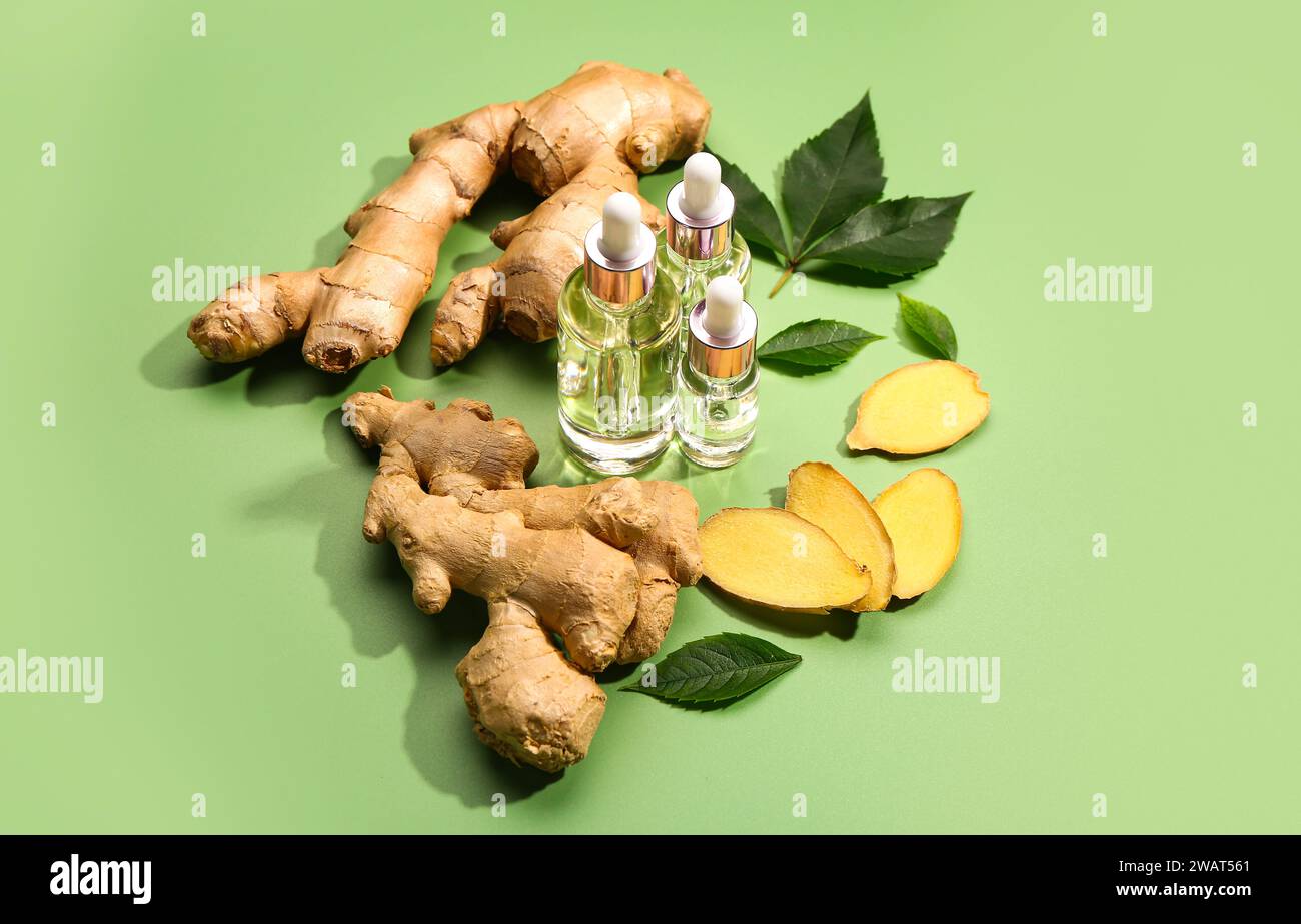 Bottles of ginger cosmetic oil and leaves on green background Stock ...