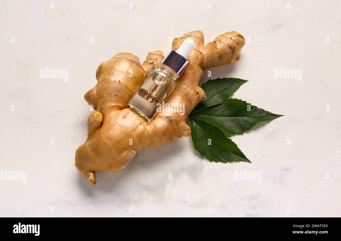 Bottle of ginger cosmetic oil and leaves on white background Stock ...