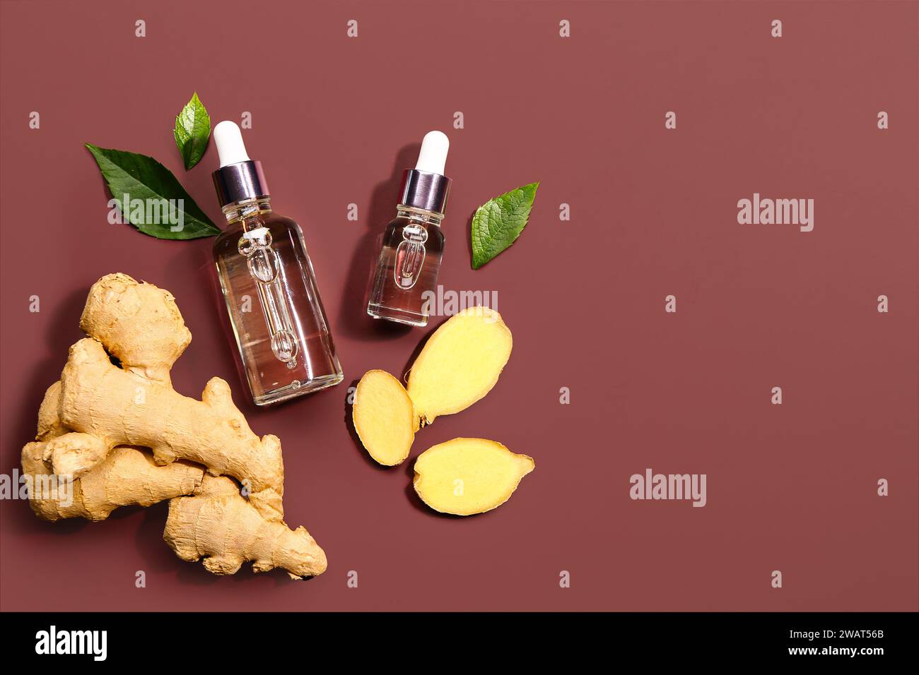 Bottles of ginger cosmetic oil and leaves on brown background Stock ...