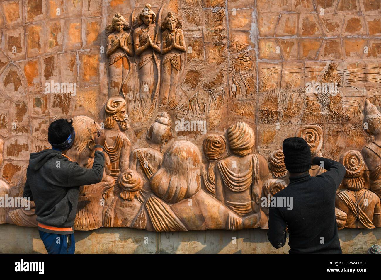 Ayodhya, India. 27th Dec, 2023. Labourers work on an art sculpture that ...