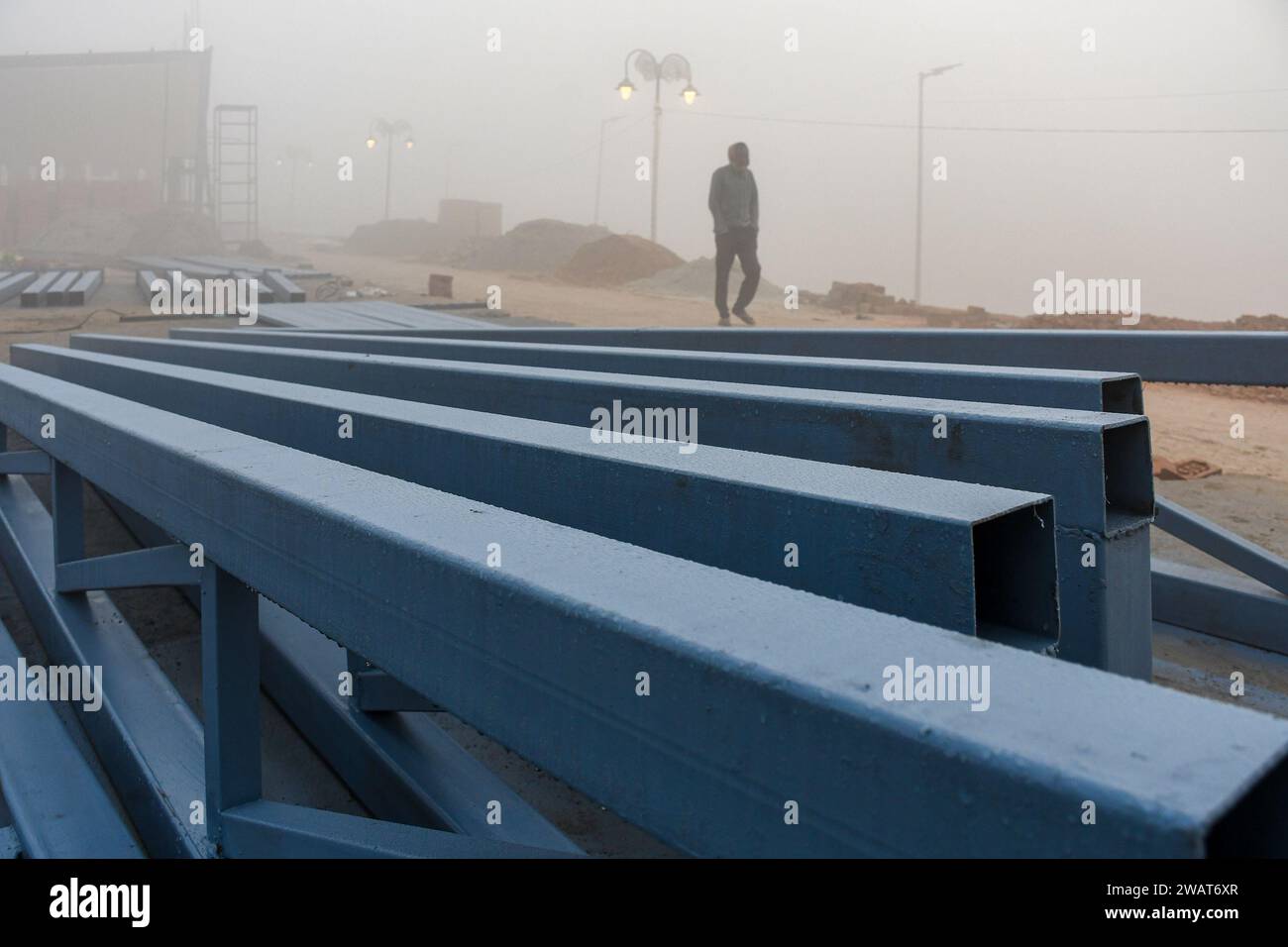 Ayodhya, India. 27th Dec, 2023. A man walks along building materials ...