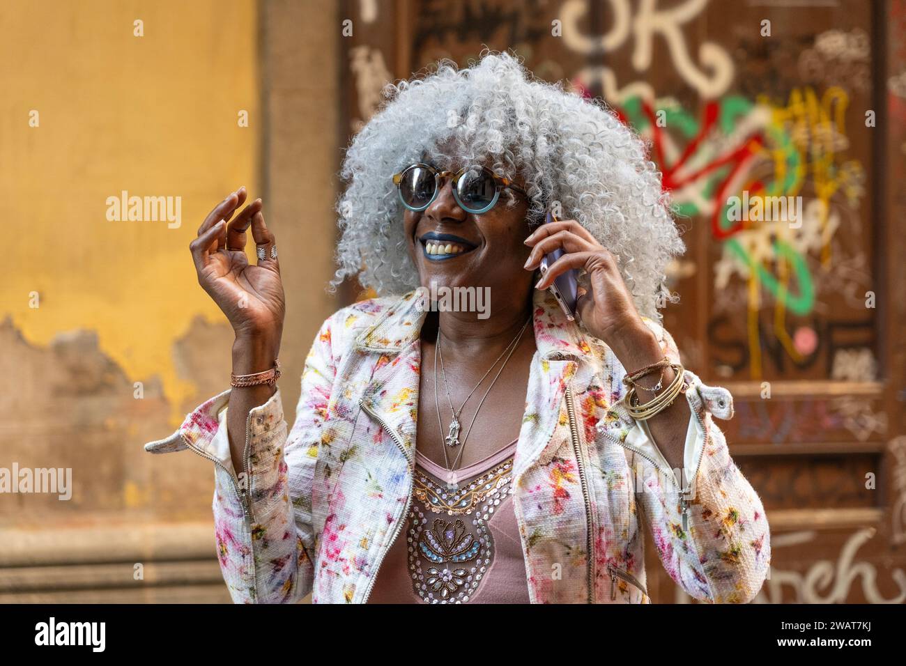 Stylish, afro-american lady with hoary afro hair and sunglasses talking ...