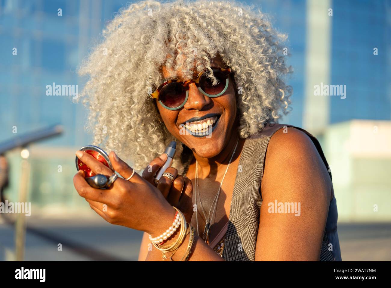 Expressive, black lady with hoary afro hair and sunglasses putting on ...