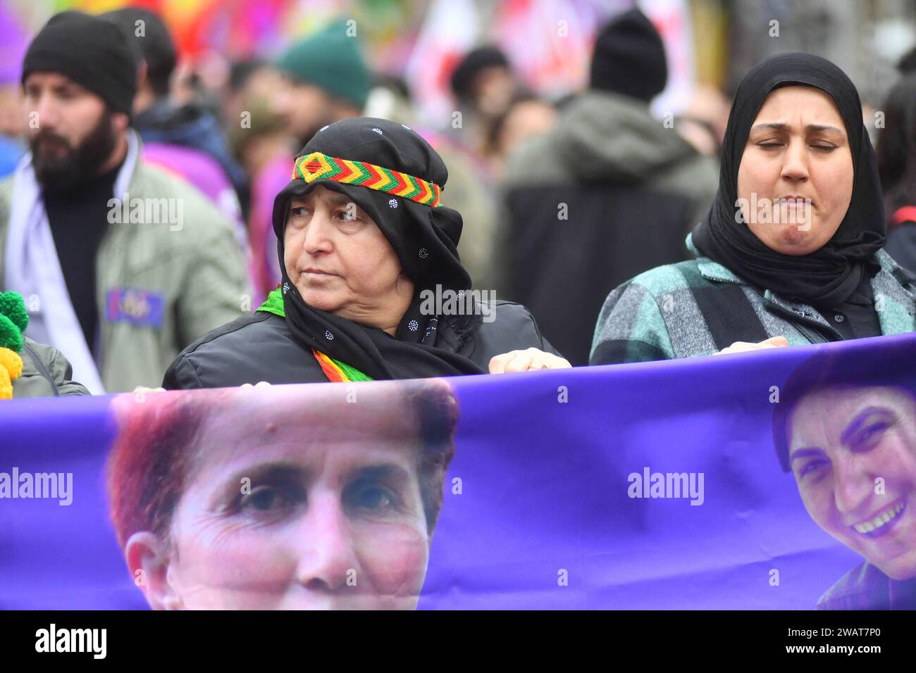 People hold a Kurdistan Workers' Party (PKK) flag and wave flags ...