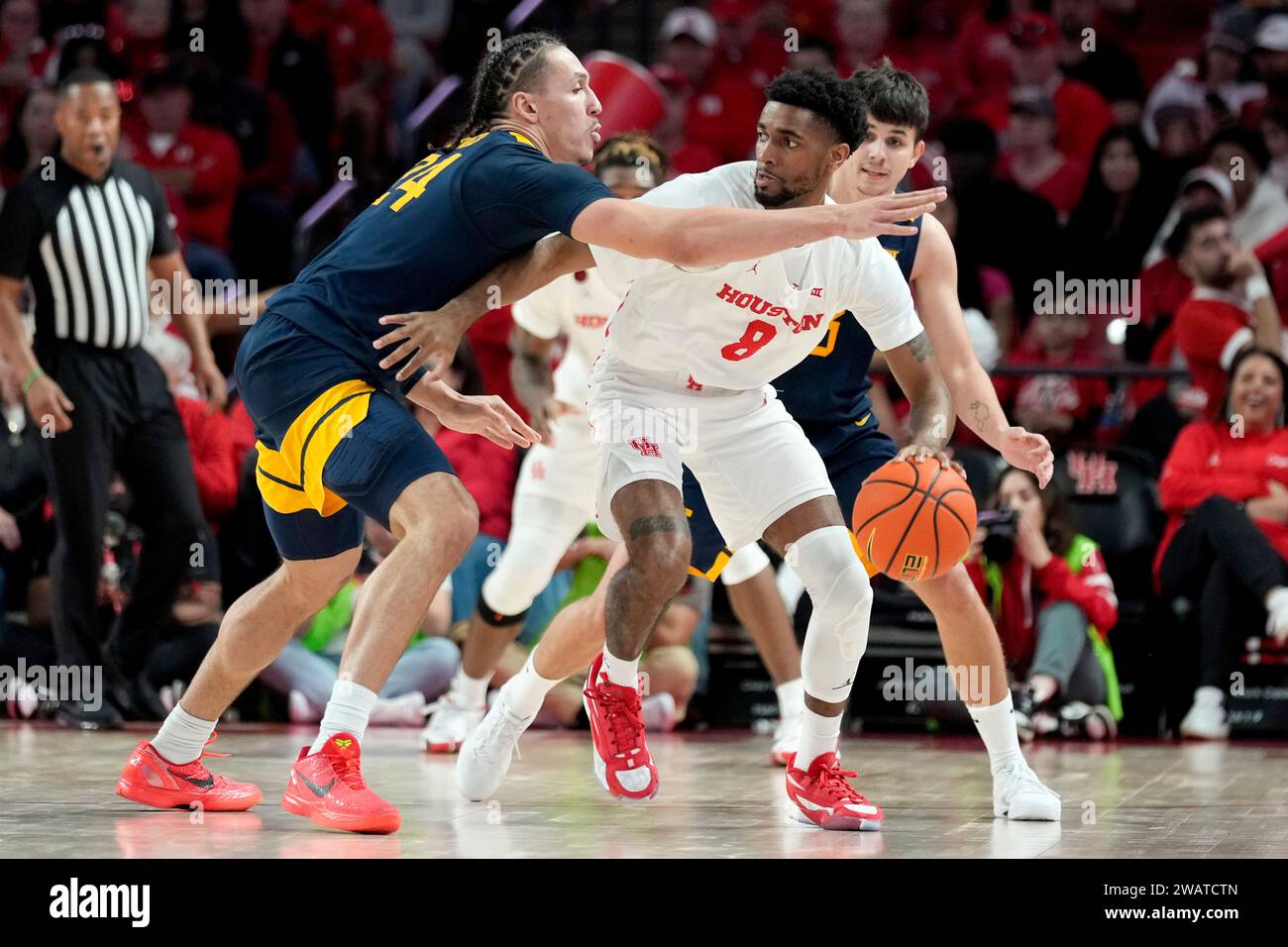 Houston guard Mylik Wilson, right, dribbles as West Virginia forward ...