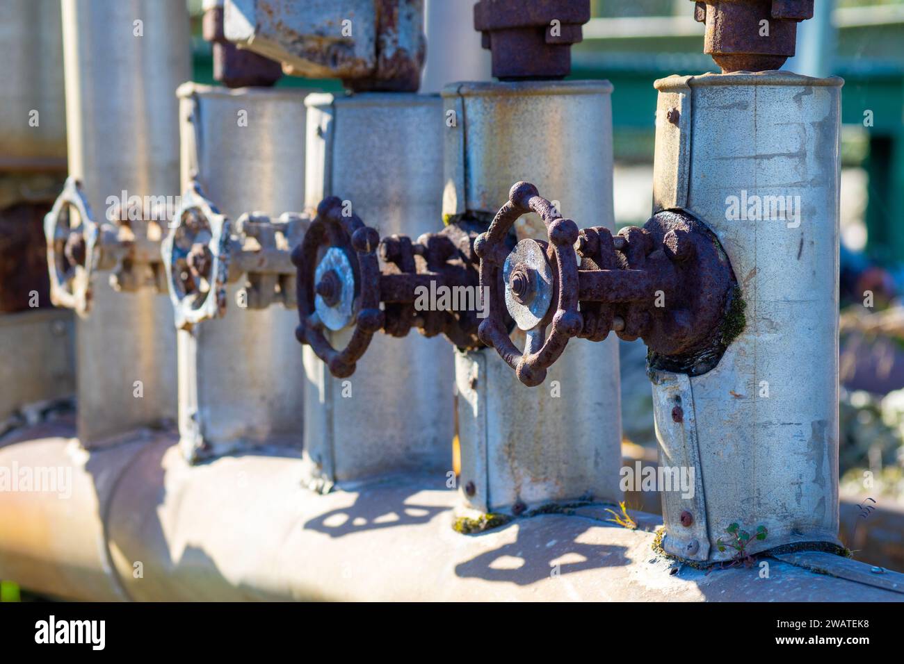 4 old and rusty faucets lined up in a chemical factory, different focus ...