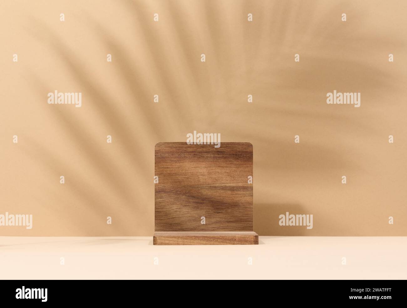 Wooden platform, shadow from a palm leaf on a brown background. Place ...