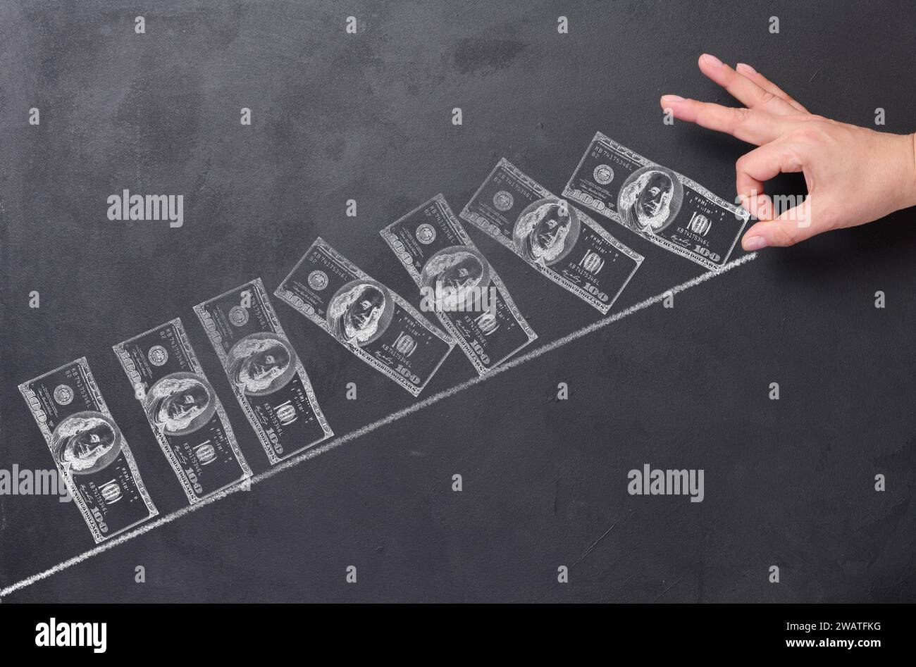 Chalk drawn American dollar bills falling like dominoes with a push ...