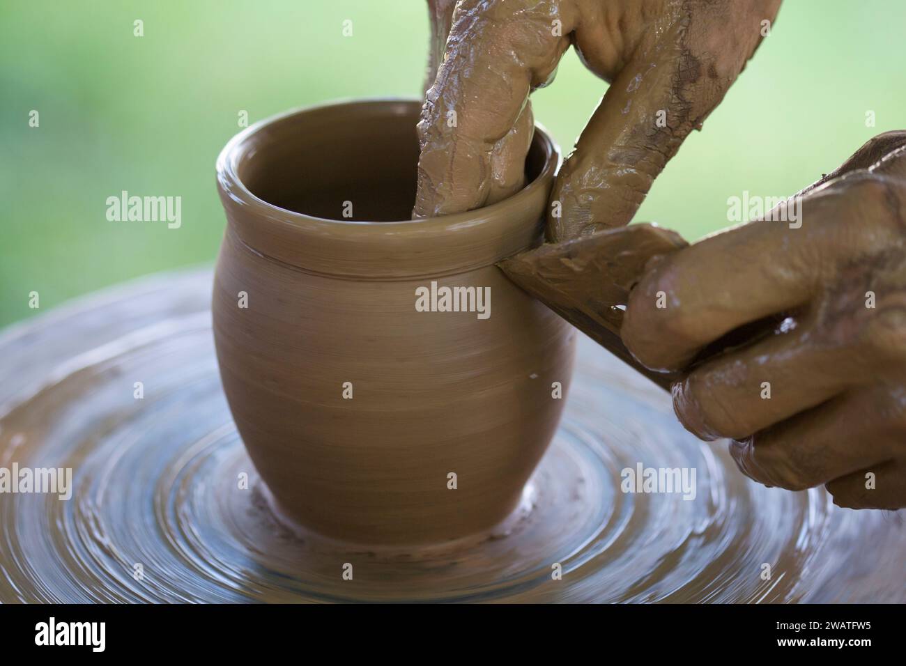 Mud clay art on wheel with hands Stock Photo - Alamy