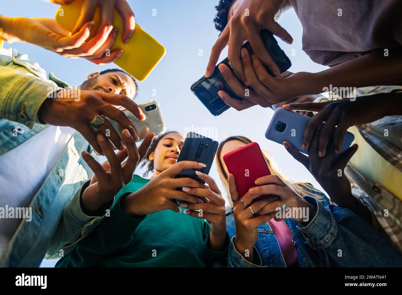 Young group of people using mobile phone device standing in circle ...