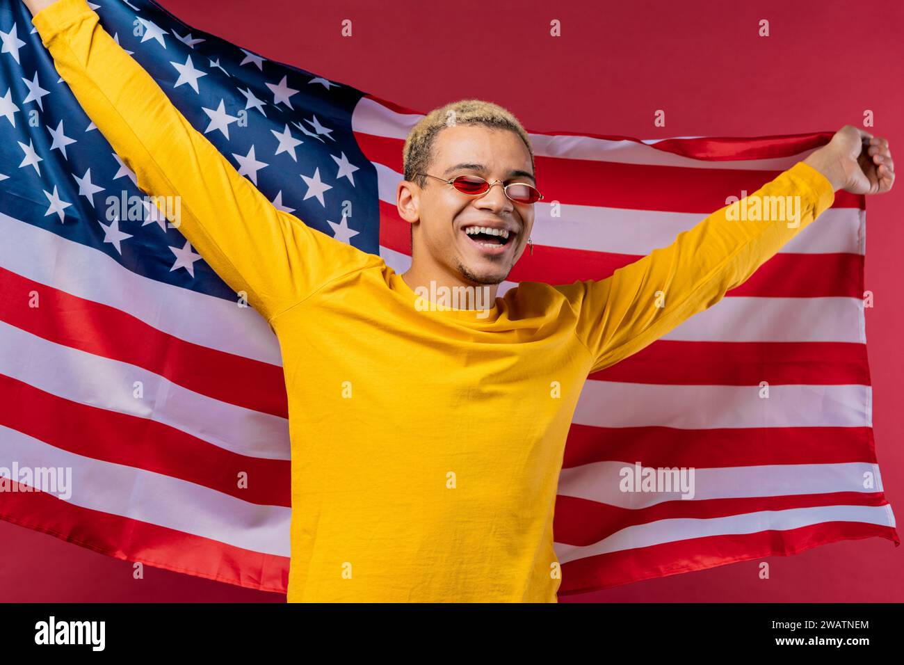 Happy man with national USA flag on red background. American patriot ...