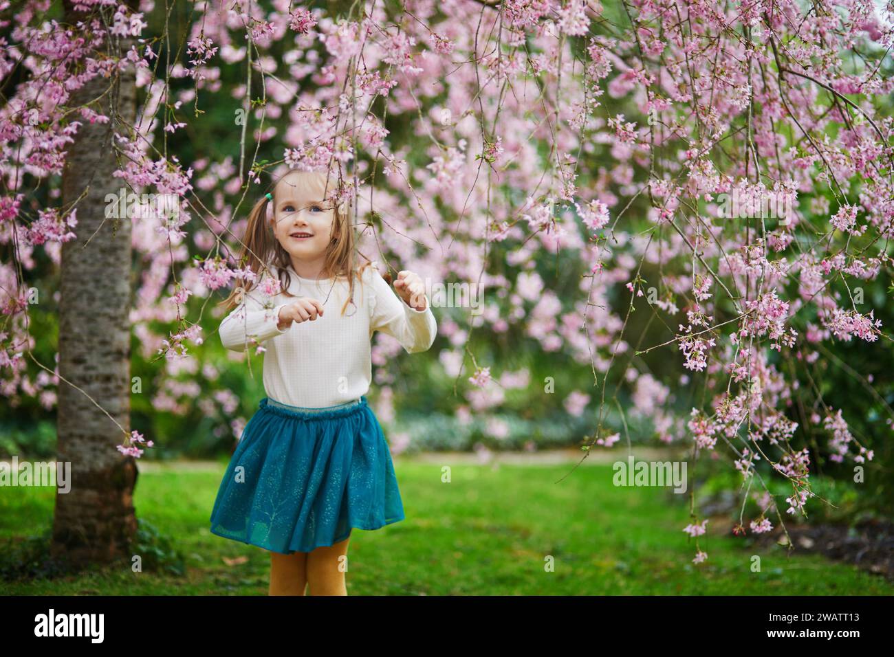 Adorable preschooler girl enjoying nice spring day in park during ...