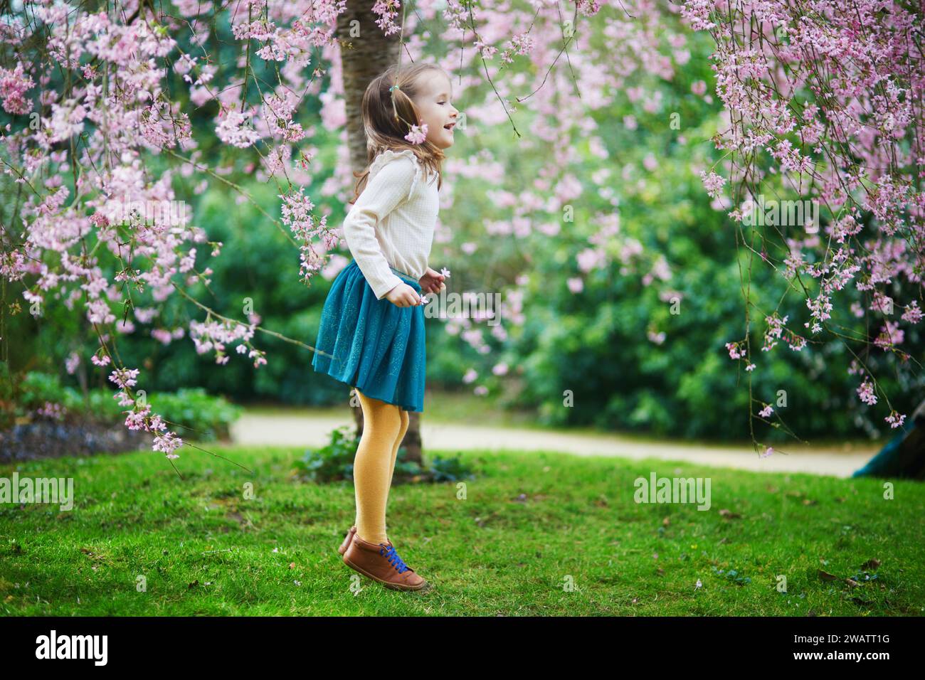 Adorable preschooler girl enjoying nice spring day in park during ...