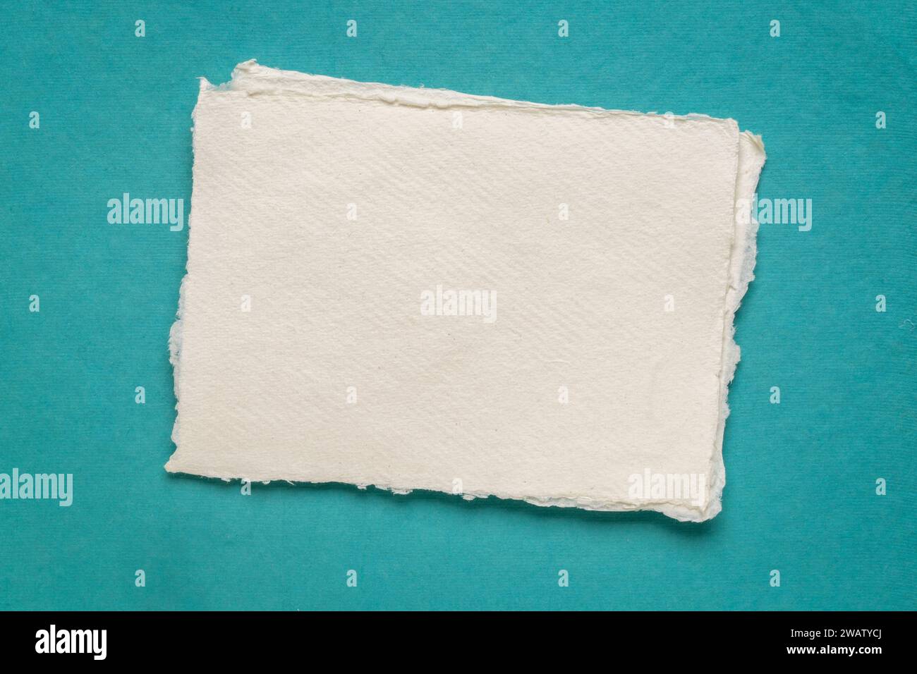 small sheet of blank white Khadi rag paper from India against blue art ...