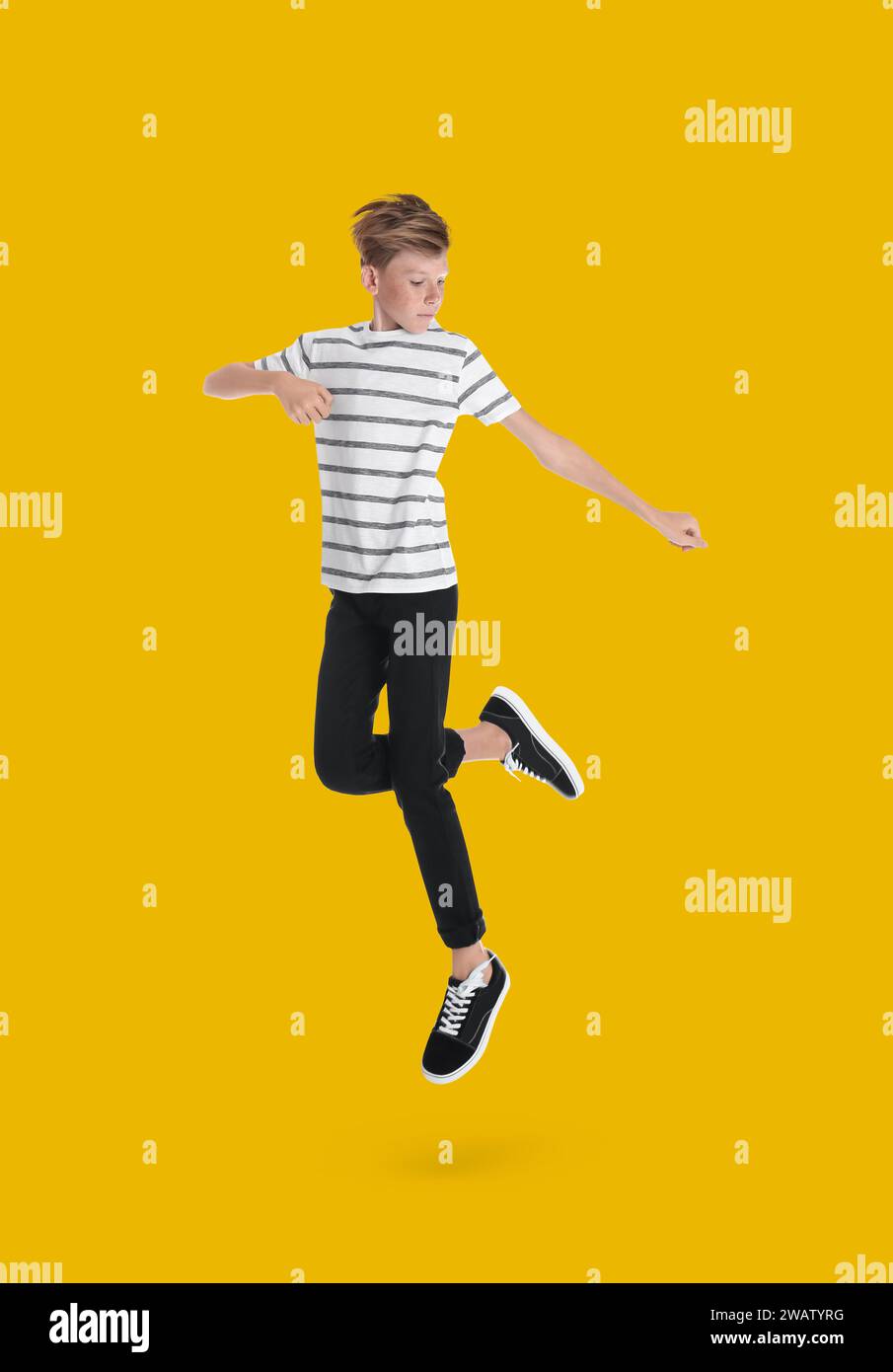 Teenage boy jumping on golden background, full length portrait Stock ...