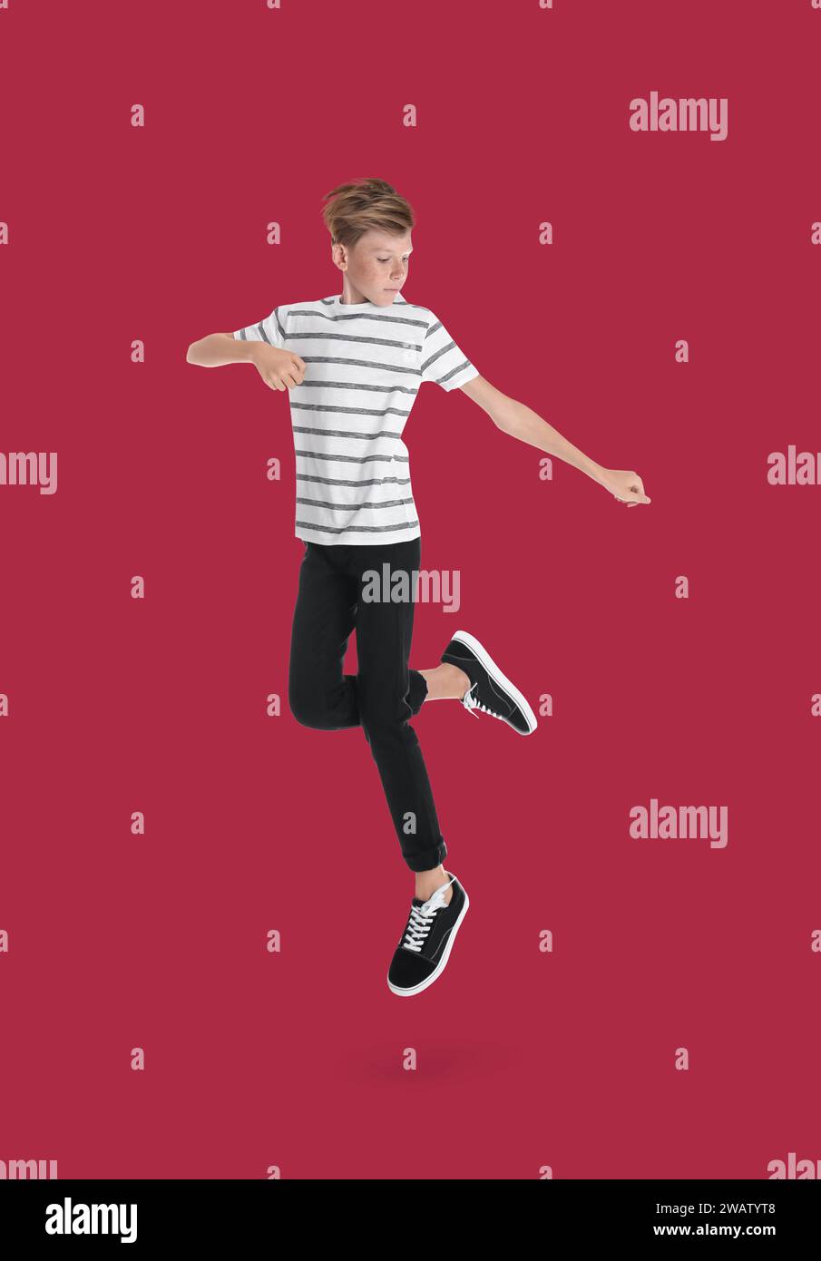 Teenage boy jumping on red background, full length portrait Stock Photo ...