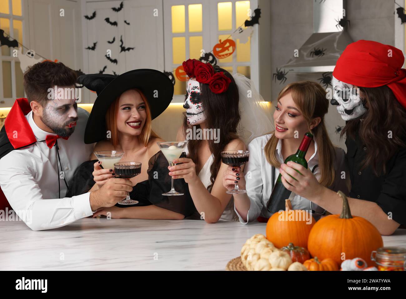 Group of people in scary costumes with cocktails celebrating Halloween ...