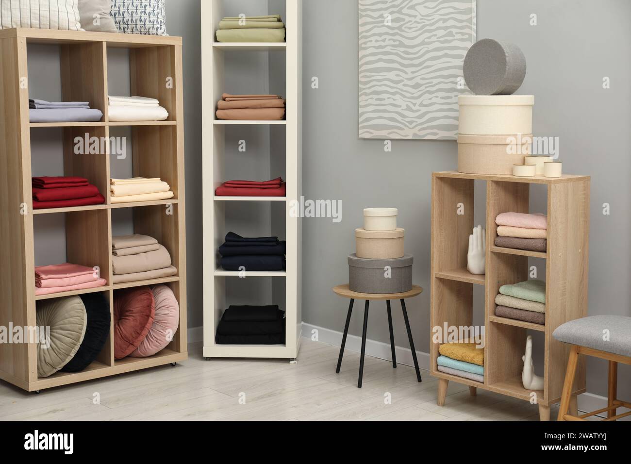 Different colorful bed linens and decorative boxes on display in home ...