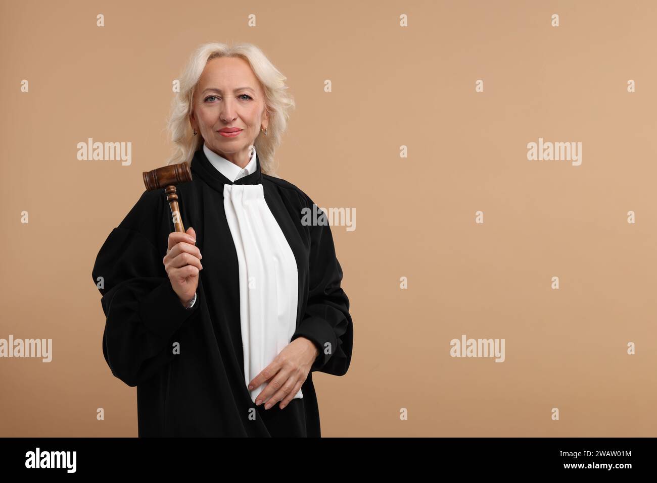 Senior judge with gavel on light brown background. Space for text Stock ...