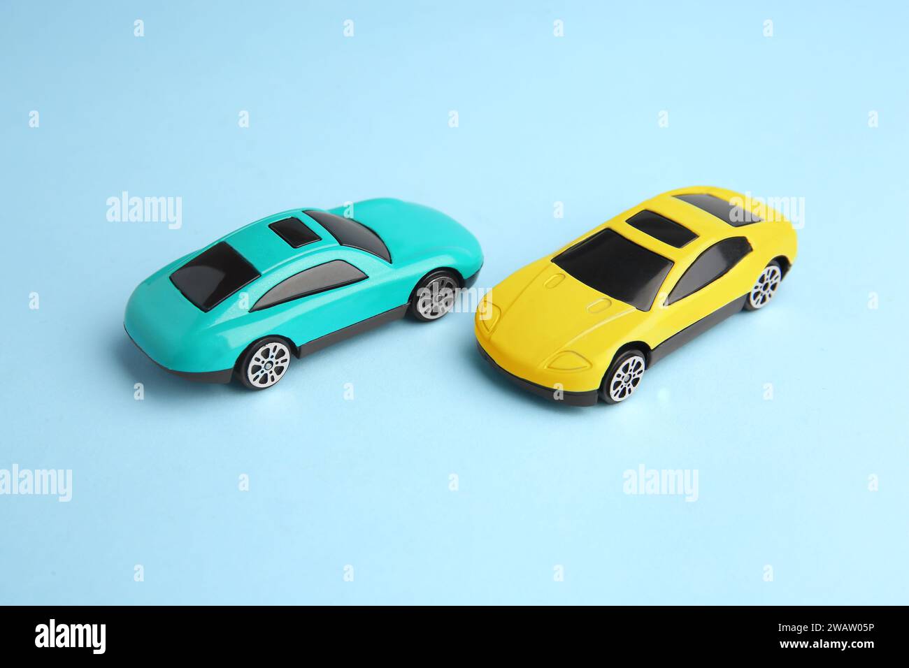 Two bright cars on light blue background. Children`s toys Stock Photo ...