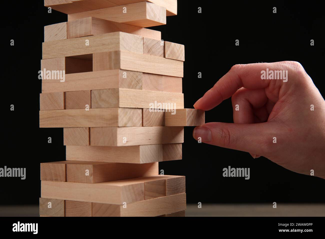 Woman playing Jenga on black background, closeup Stock Photo - Alamy