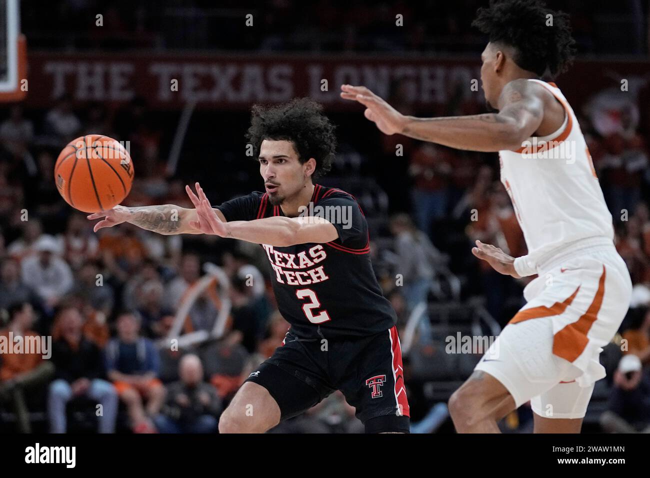 Texas Tech guard Pop Isaacs (2) passes the ball around Texas forward ...