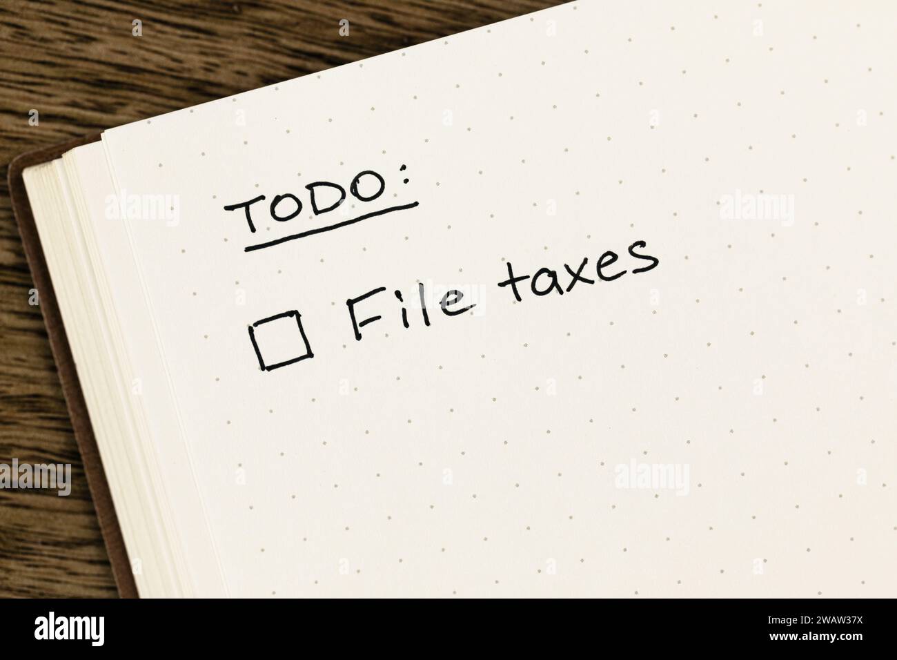 To-do list with 'File taxes' checkbox reminder handwritten on an open ...