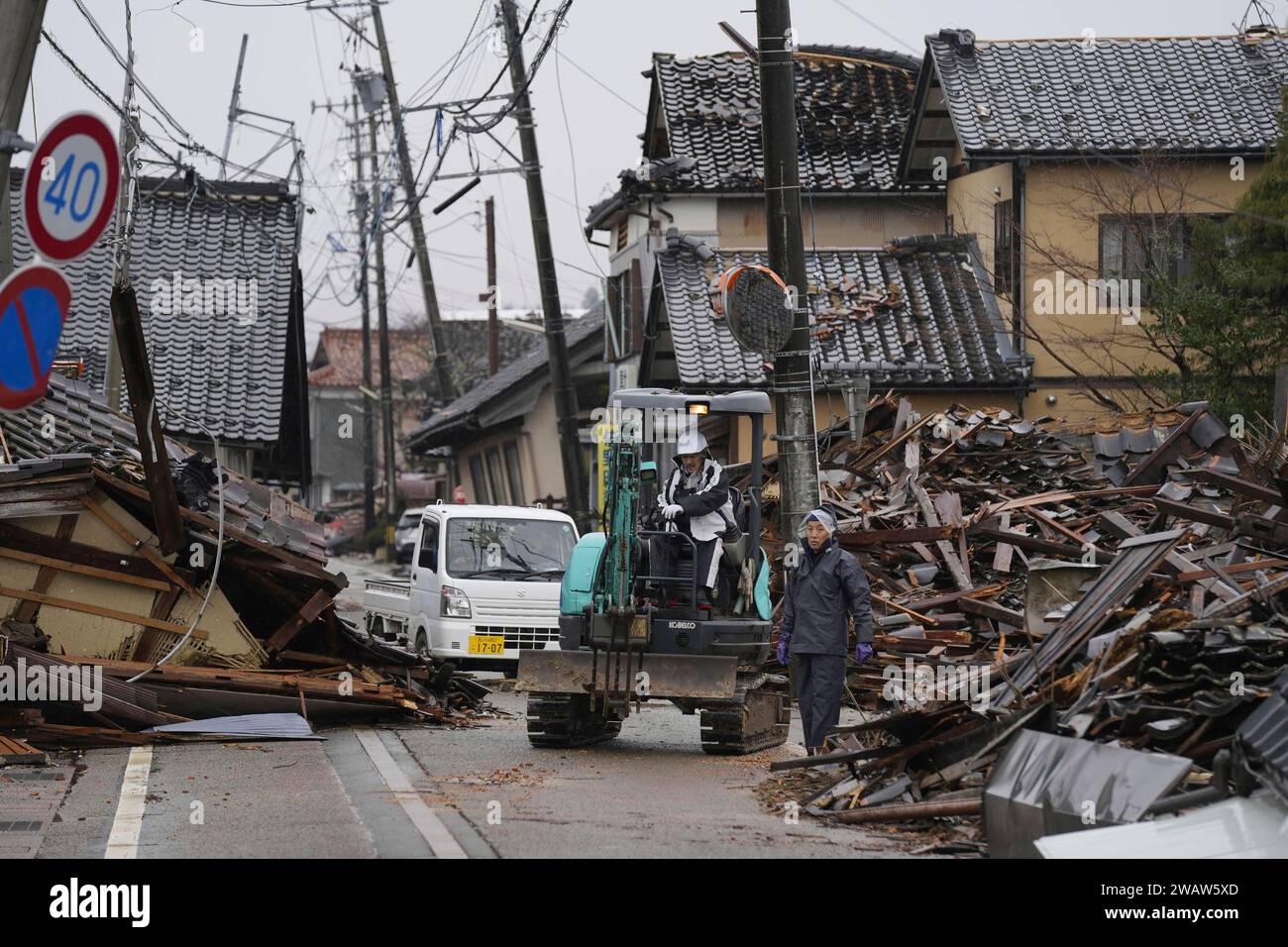 A heavy machinery advances near the wreckage of destroyed houses in ...