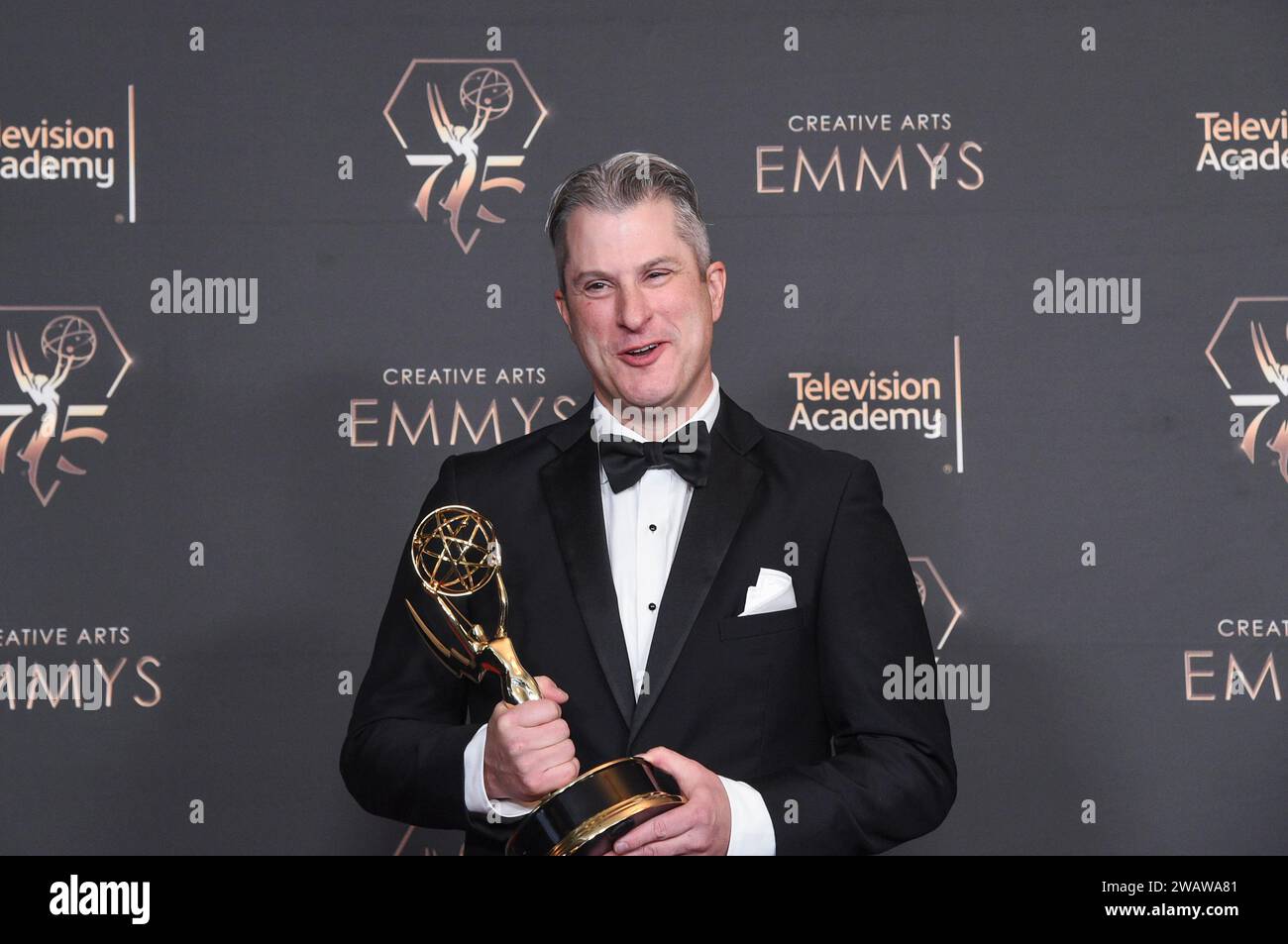 Chris Poulos poses in the press room with the award for outstanding ...