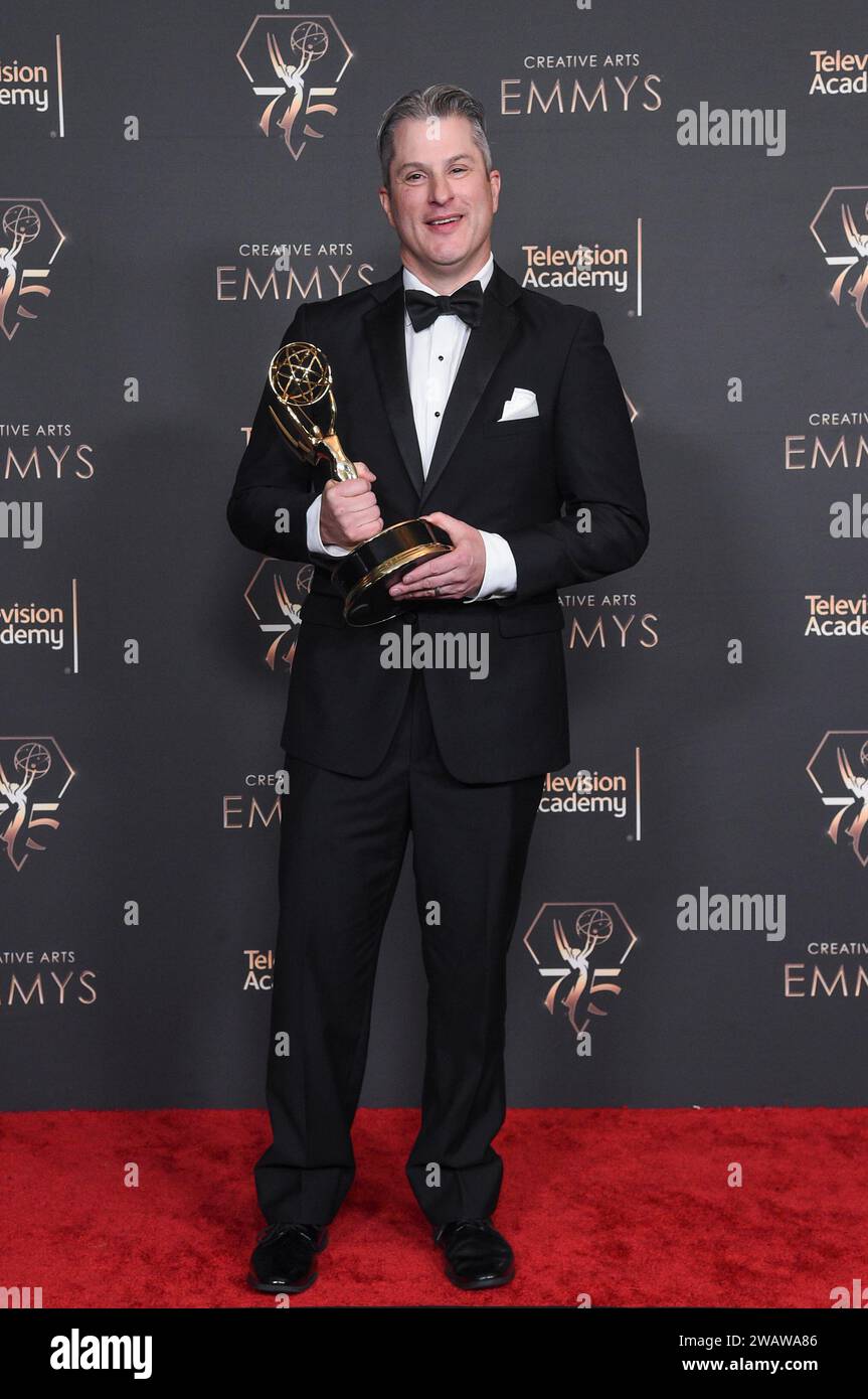 Chris Poulos poses in the press room with the award for outstanding ...