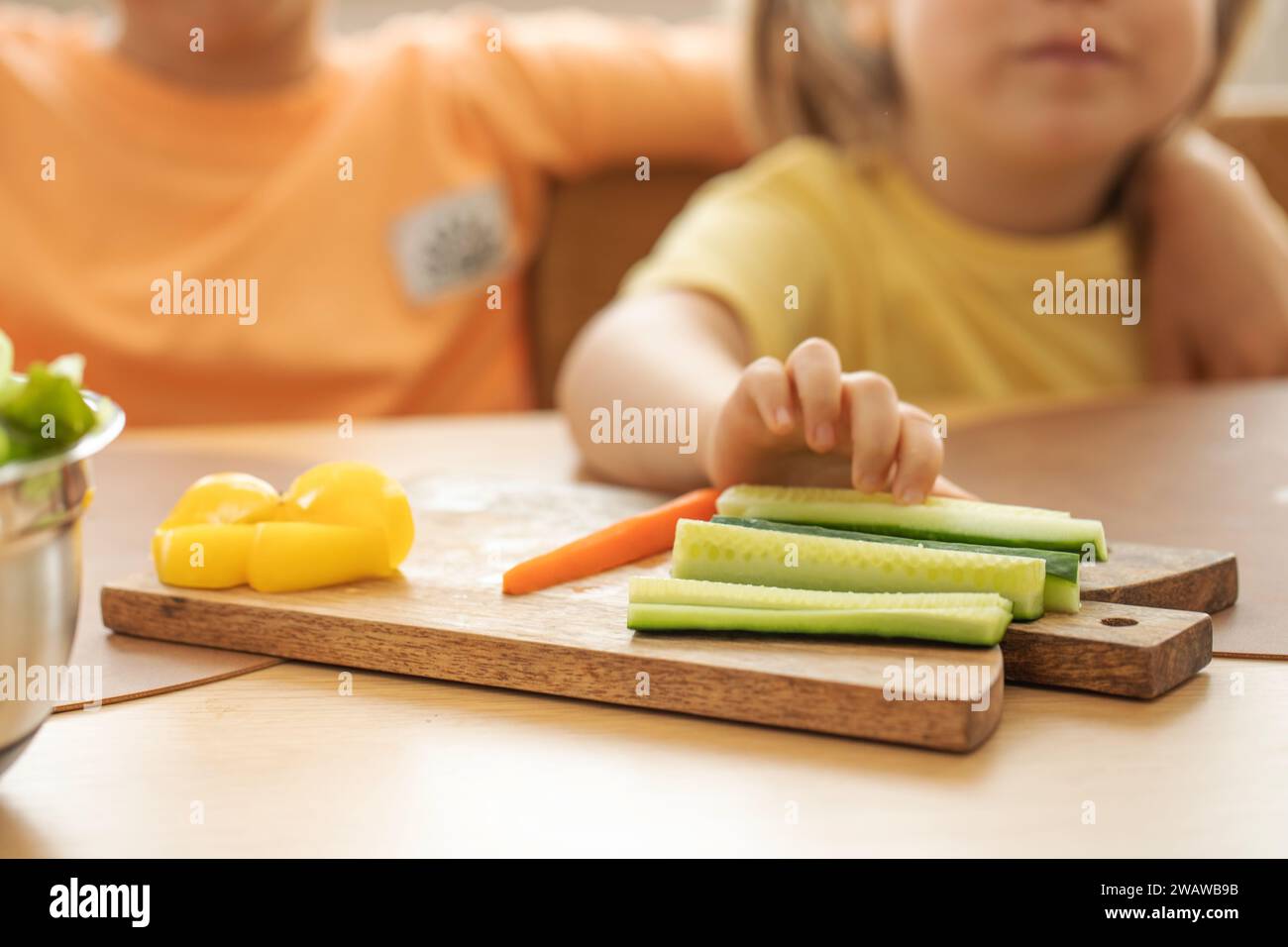 Children take sticks of fresh sticks of carrots and cucumbers. Healthy ...