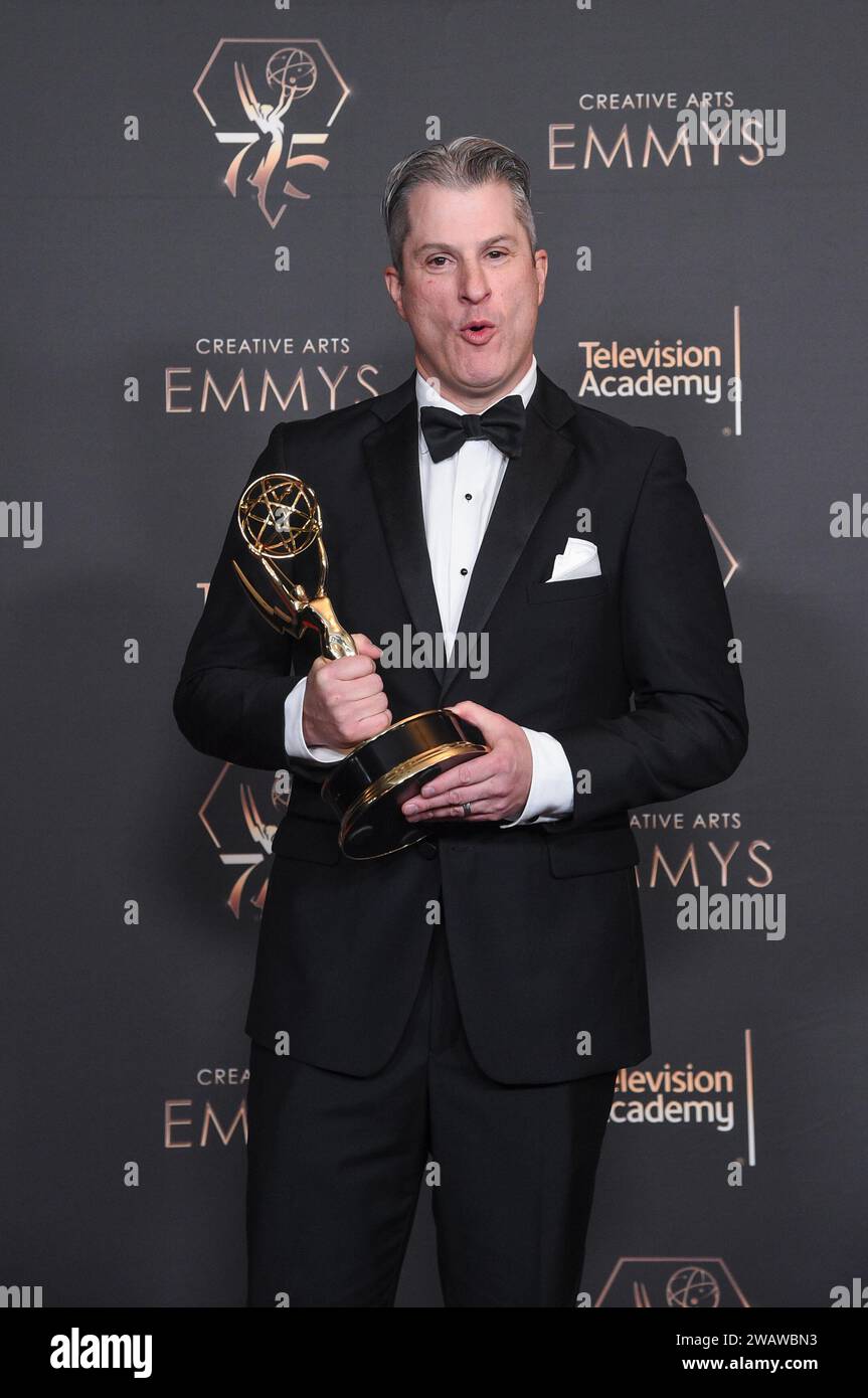 Chris Poulos poses in the press room with the award for outstanding ...