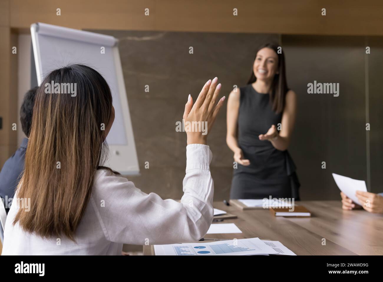 Back view of young employee woman raising hand, asking question Stock ...