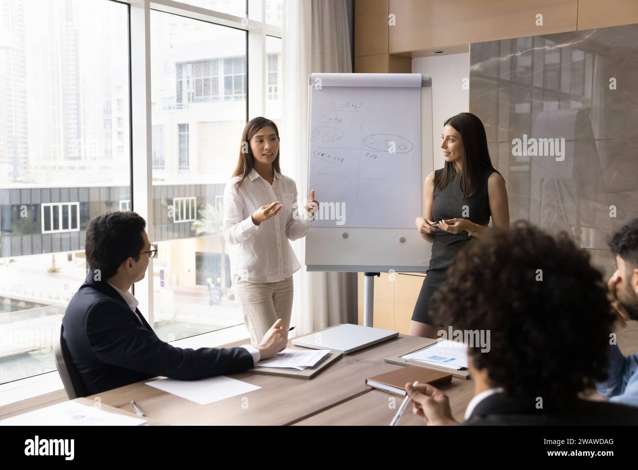 Two diverse project managers women presenting teamwork strategy Stock ...
