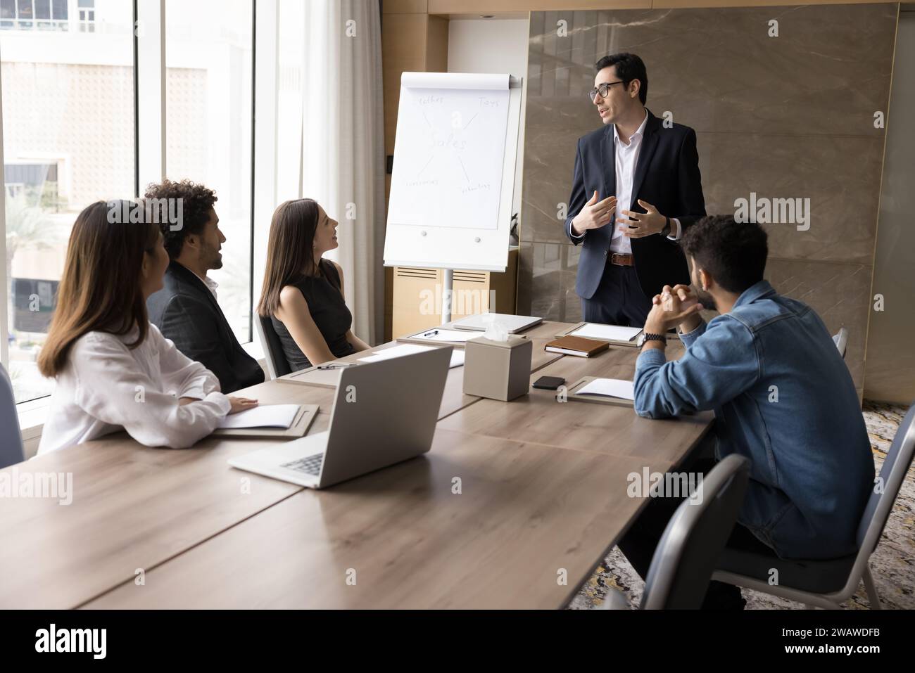Serious business leader man speaking to diverse team of colleagues ...