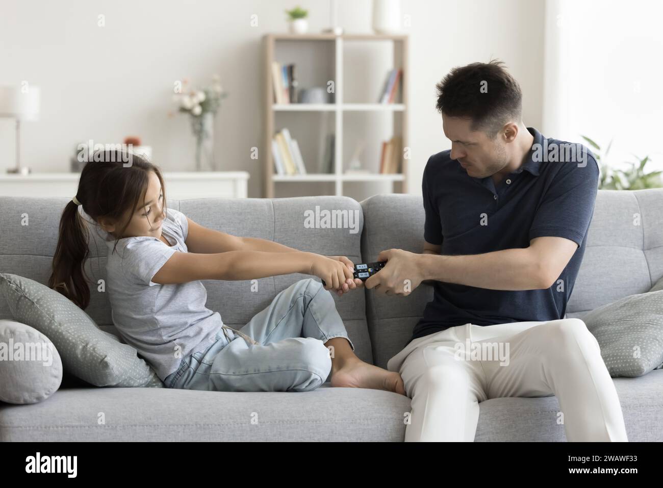 Serious father and naughty little kid fighting for remote control Stock ...
