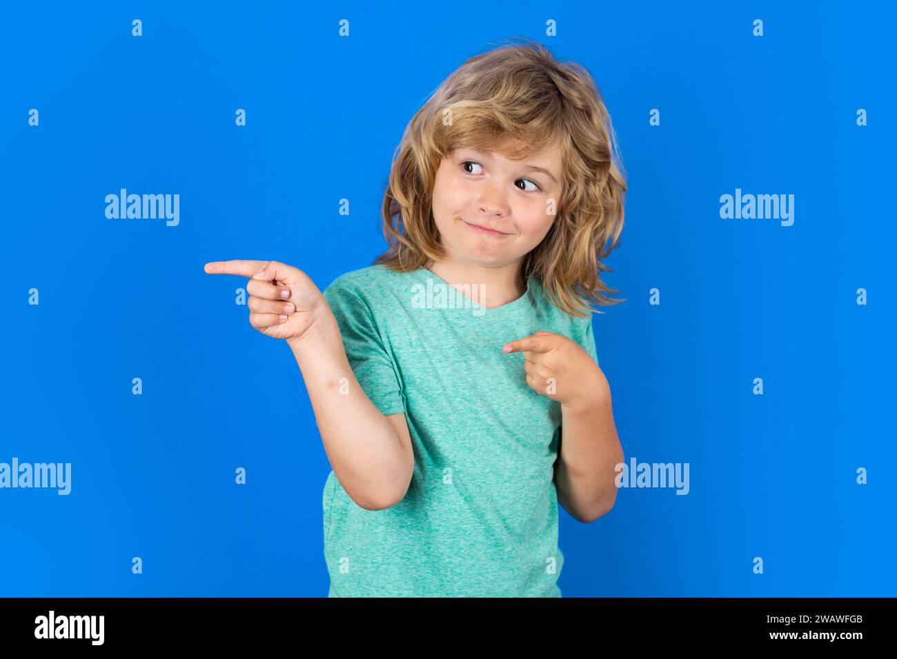 Child pointing away on isolated studio background. Kid with index ...