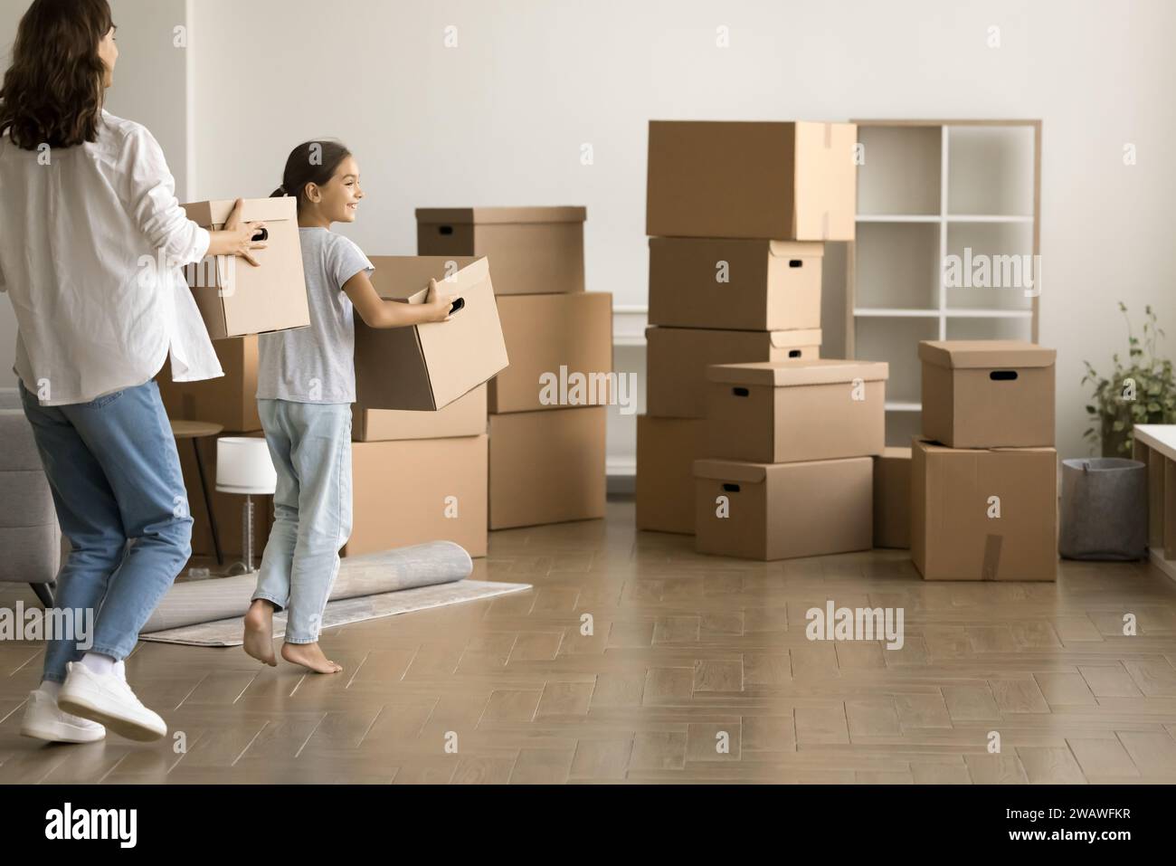 Pretty daughter and mom carrying moving boxes in new apartment Stock ...