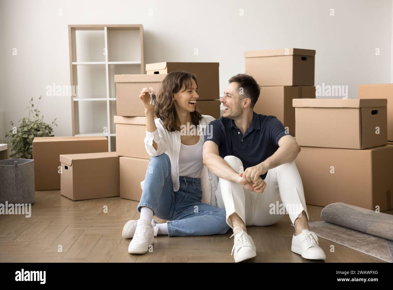 Happy excited young married couple enjoying moving process Stock Photo ...