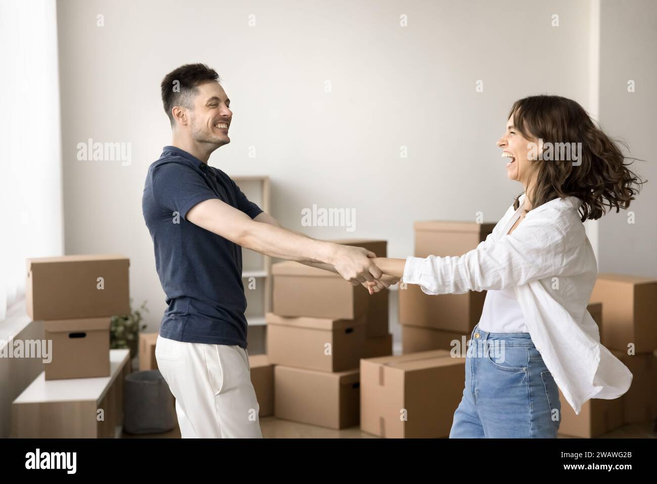 Happy excited young husband and wife celebrating first house buying ...