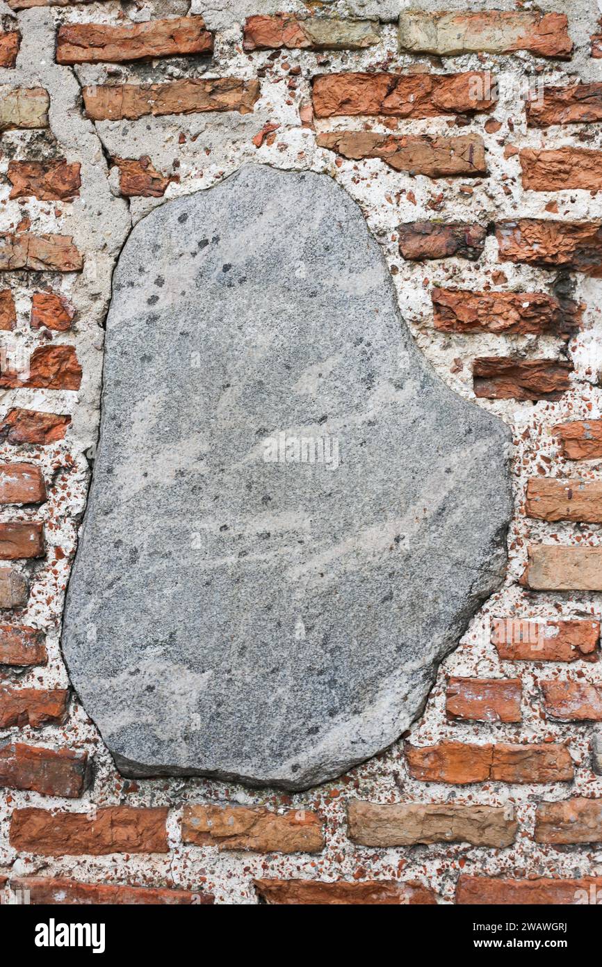 Medieval wall made of bricks with a large stone. Abstract background ...