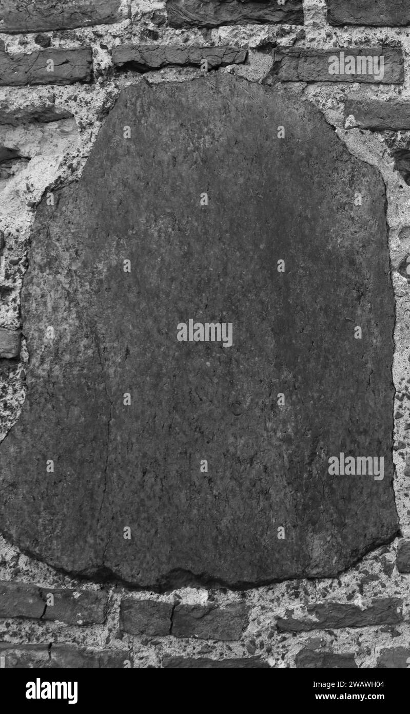 An old, medieval wall made of bricks and a large stone Stock Photo - Alamy